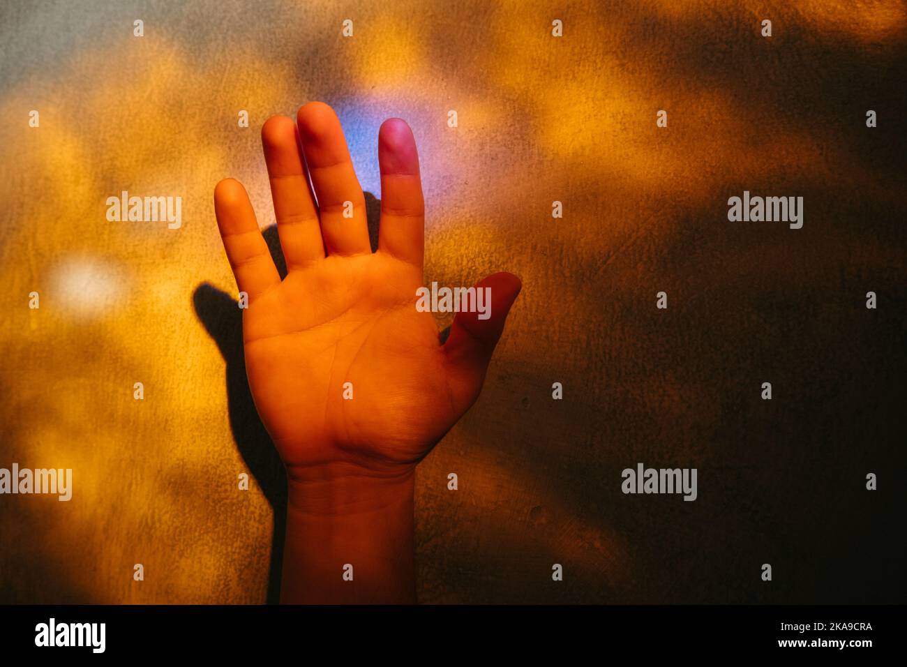 A Person holding hand up to the light touching rays of warm Stock Photo ...
