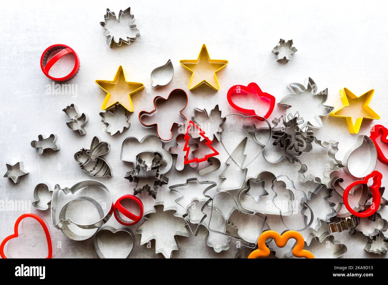 Top down view of many assorted cookie cutters against a light ...