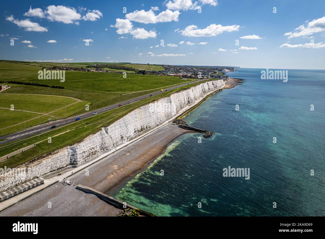 An aerial view of white chalk cliffs and the seafront promenade in ...