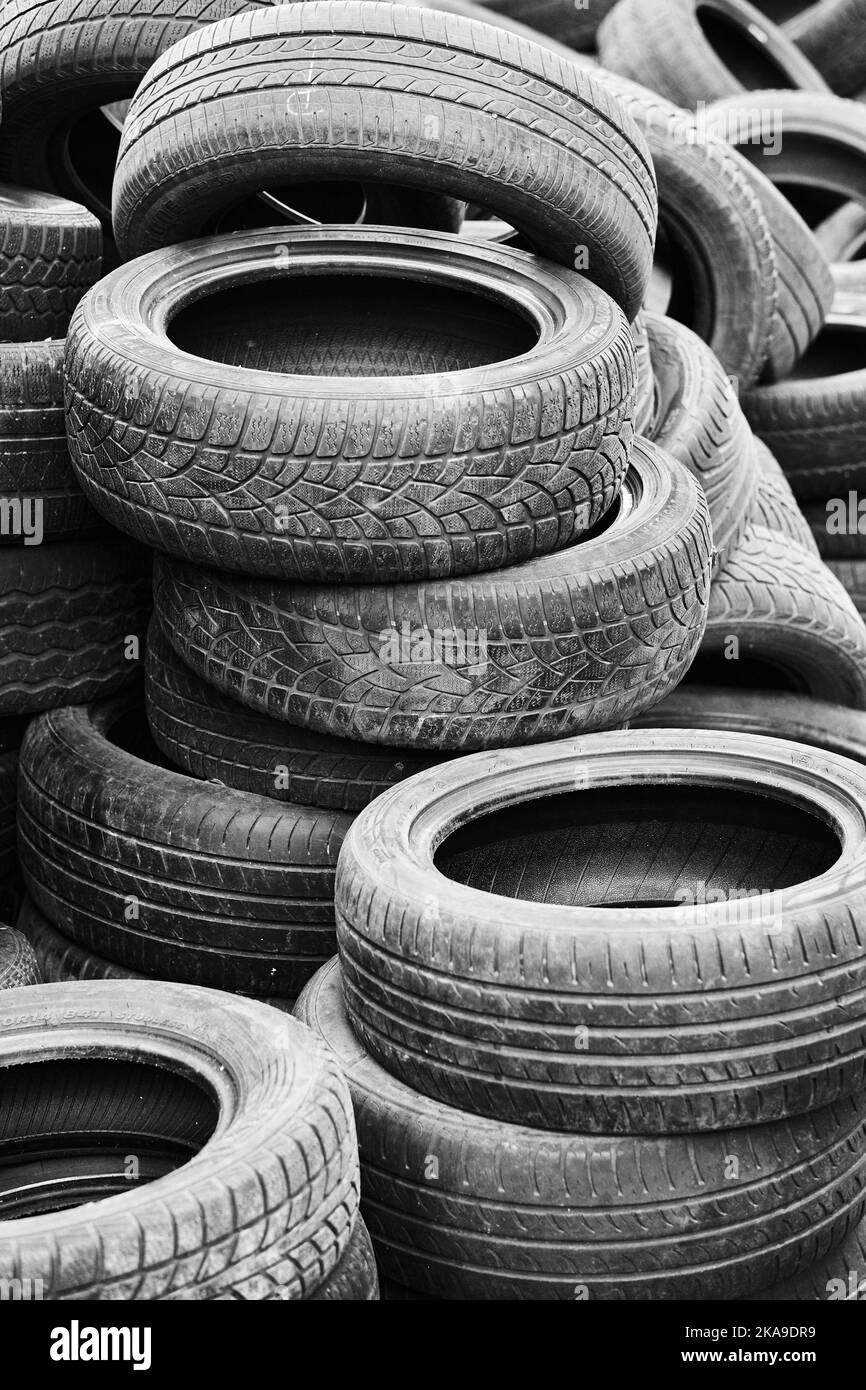 A vertical grayscale shot of many used old car tires- perfect for ...
