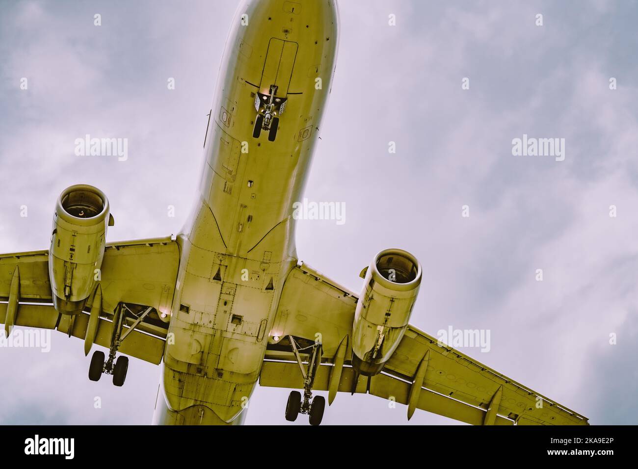 A low angle shot of an airplane flying against a cloudy blue sky Stock ...