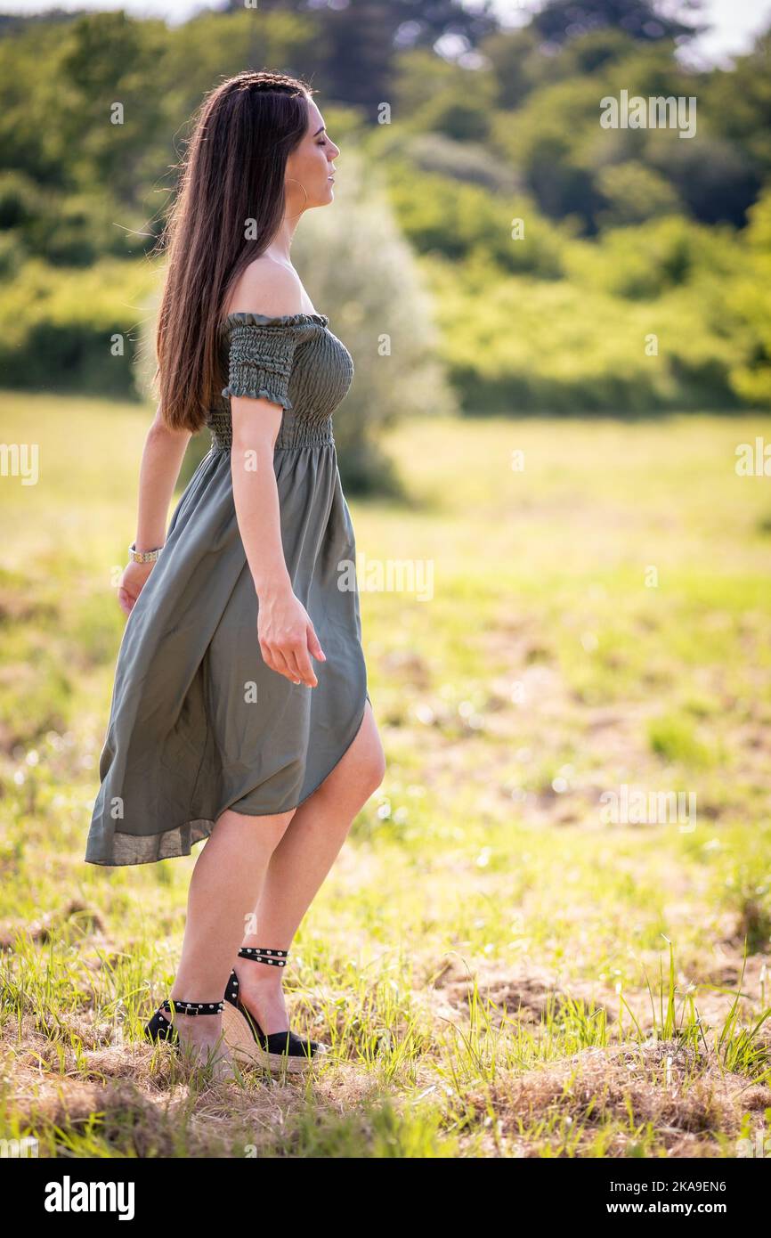 A beautiful caucasian female posing for a photo in a field on a sunny ...