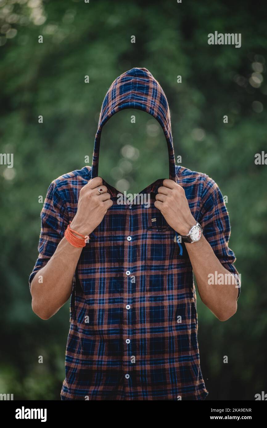 A vertical shot of the young man with an empty face wearing a blue ...