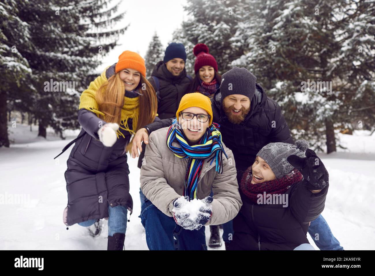 Funny cheerful friends having fun outdoors in park with snow in winter on beautiful frosty day ...