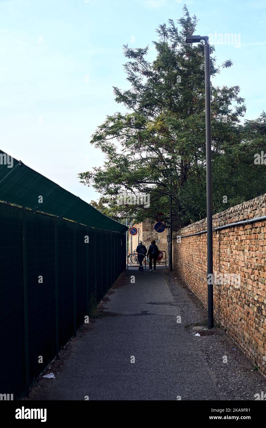Gravel path next to a boundary brick wall and a fence at sunset Stock ...