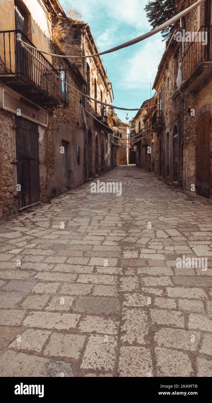 A vertical shot of a rocky street in the old town with old houses Stock ...