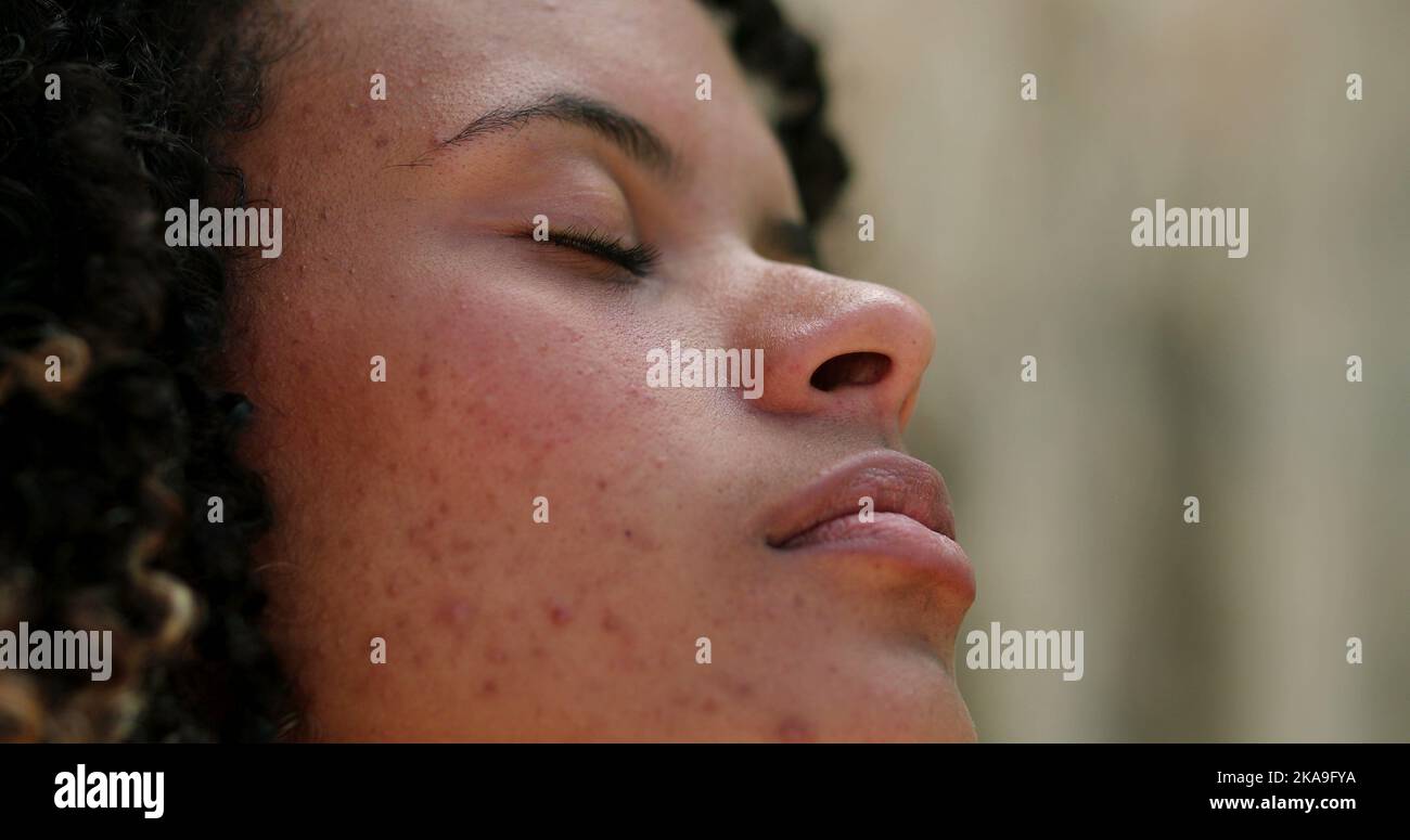 Hispanic woman face closing eyes in meditation. Close-up person opens ...