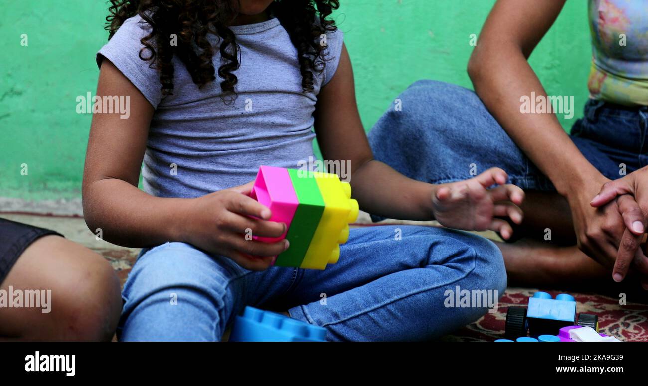 Little girl playing with building blocks. Hispanic mixed race ethnicity Stock Photo - Alamy