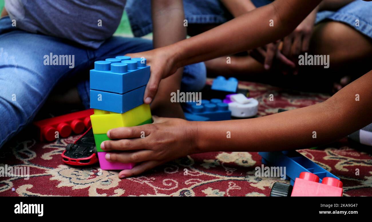 Little girl playing with building blocks. Hispanic mixed race ethnicity Stock Photo - Alamy