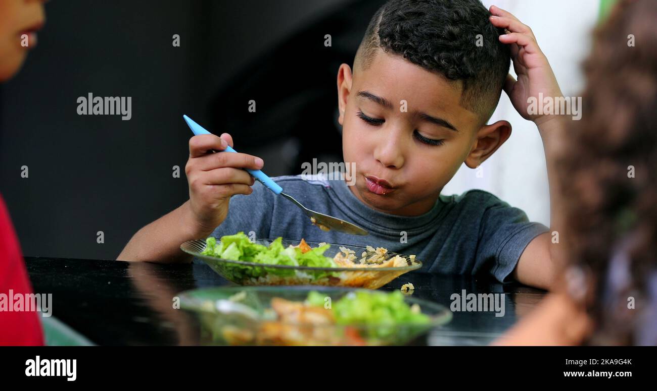 Little mixed race child eating food. Hispanic kids lunch time Stock ...
