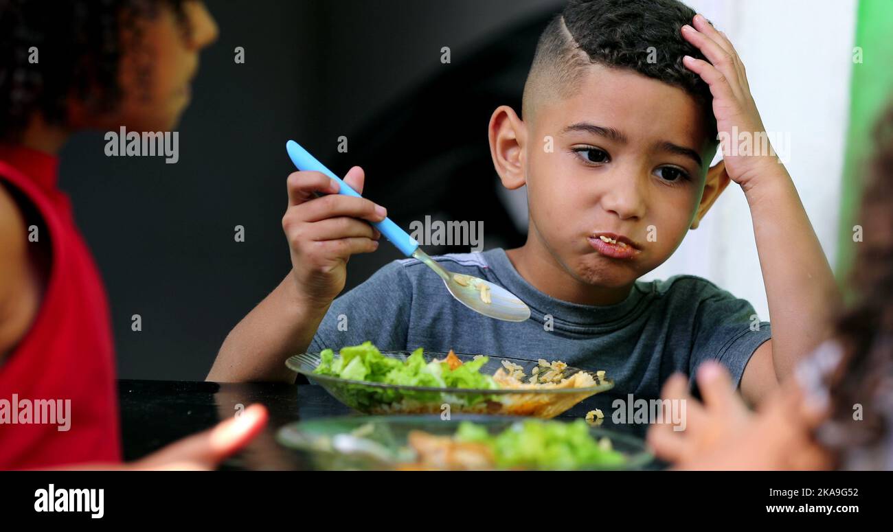 Little mixed race child eating food. Hispanic kids lunch time Stock ...