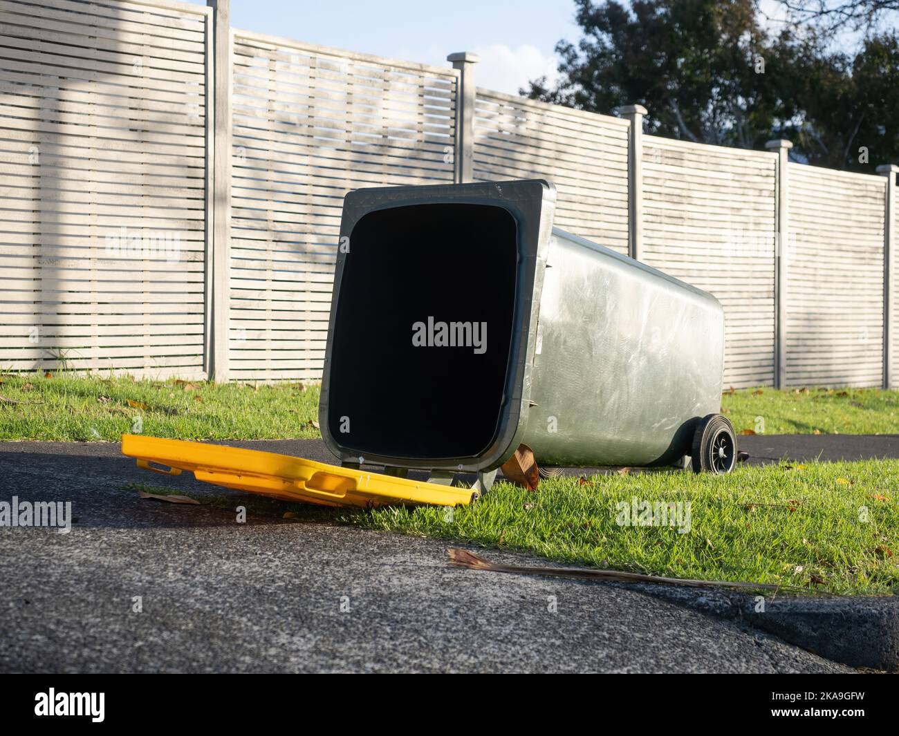 View of rubbish wheelie bins toppled by strong wind laying on ground ...