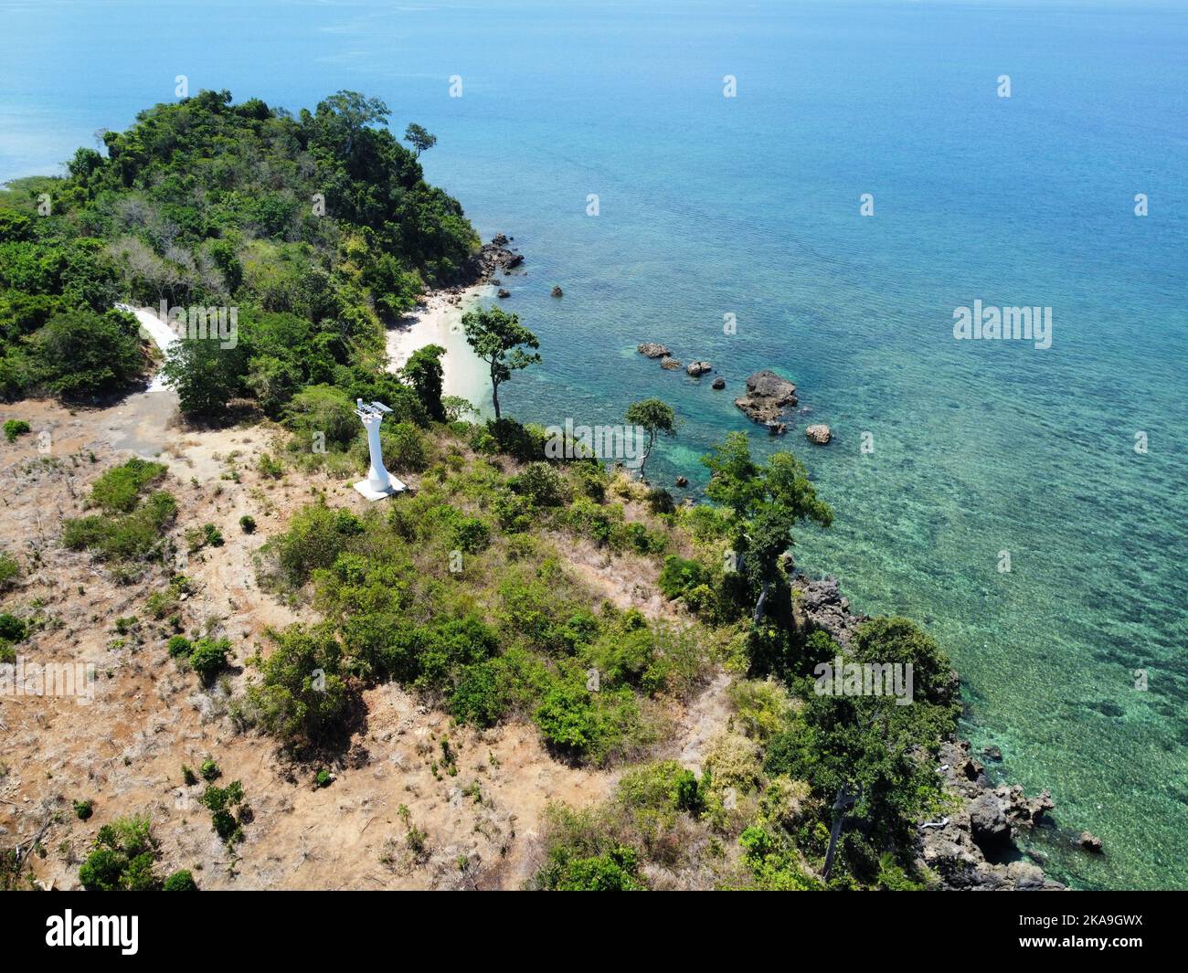 A high angle of lighthouse on a mountain covered with greenery against ...