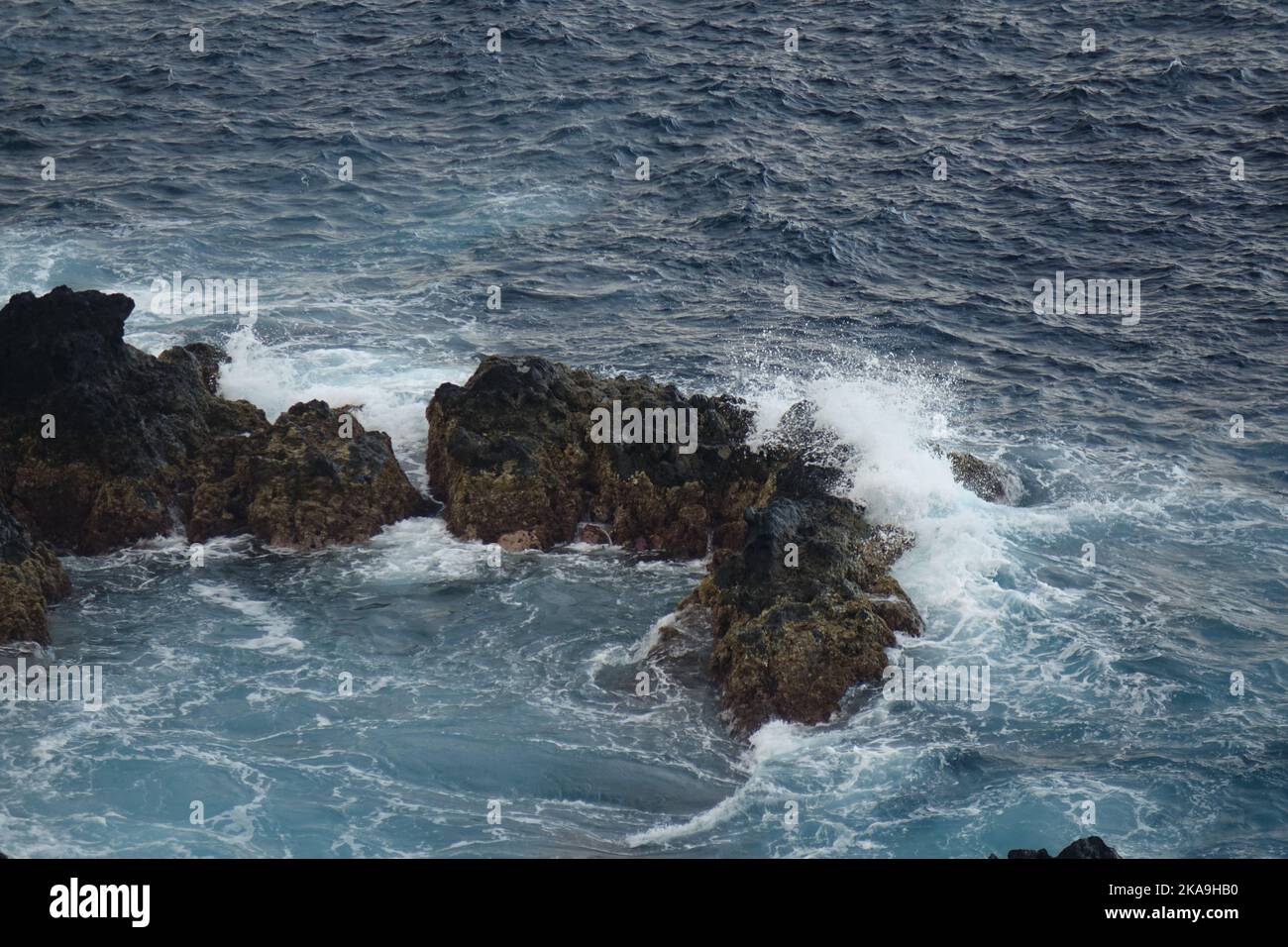 An overpass view of the ocean waves crashing over the rock formations ...