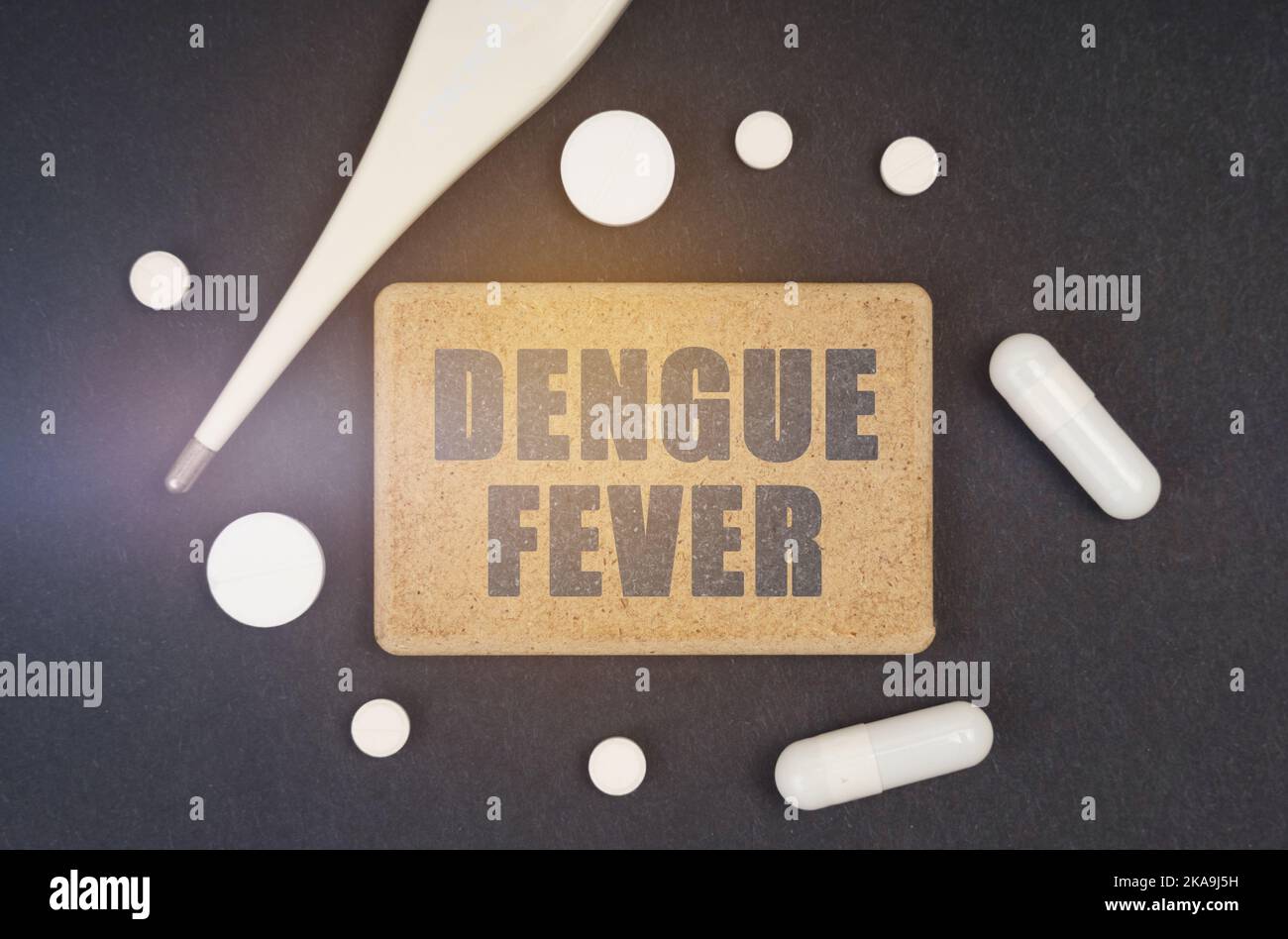 Medicine concept. On a black background, a thermometer, pills and a ...