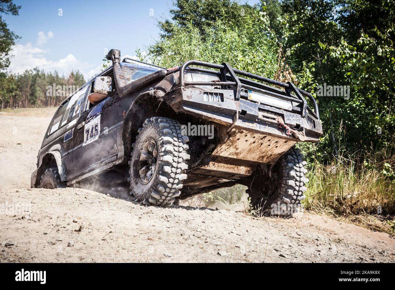 Heavy off-road racing car driving along the dusty road Stock Photo - Alamy