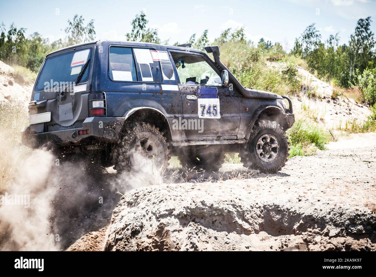 Heavy off-road racing car driving along the dusty road Stock Photo - Alamy