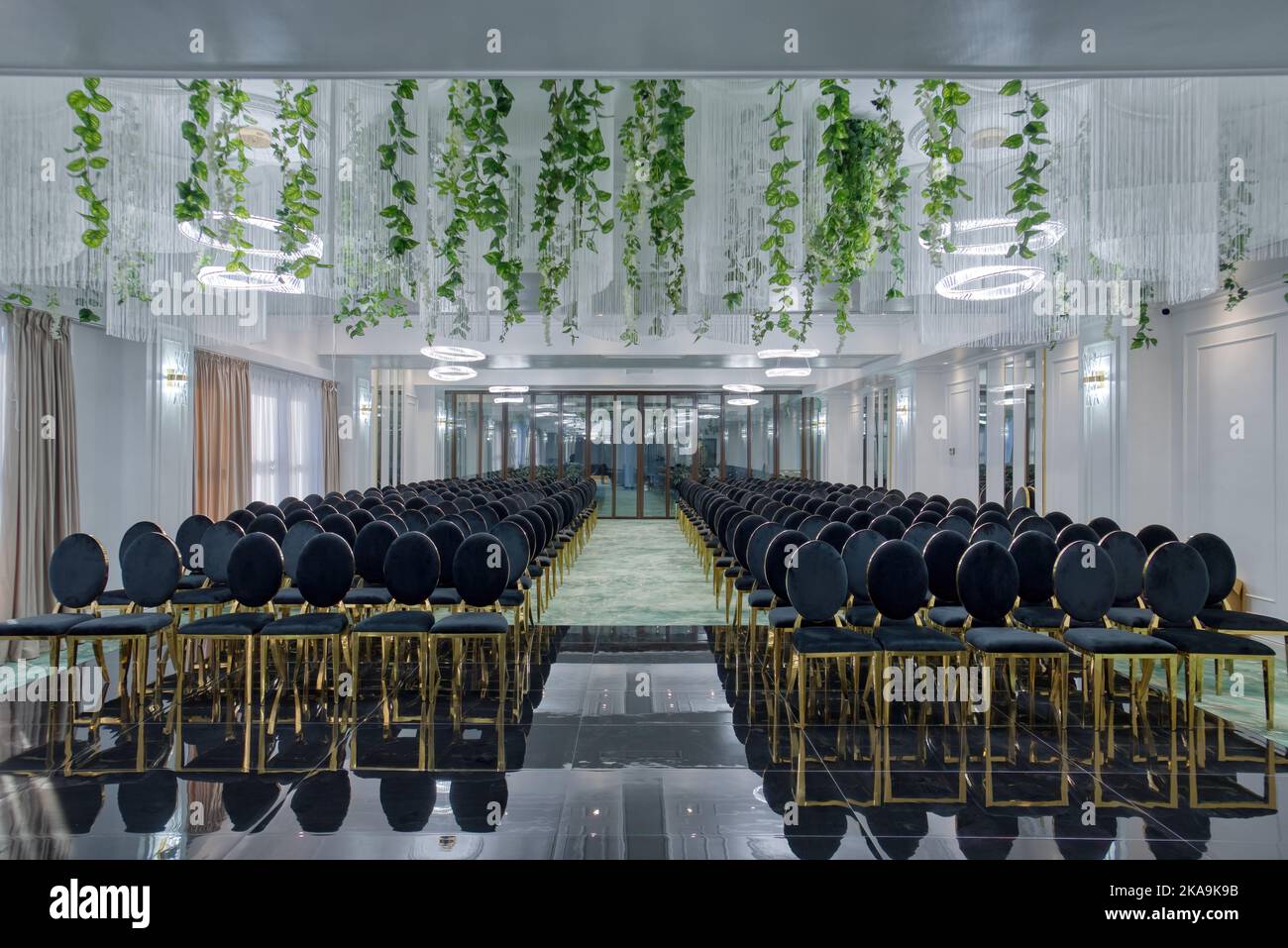 Hotel conference hall with empty chairs, green design with green plants ...