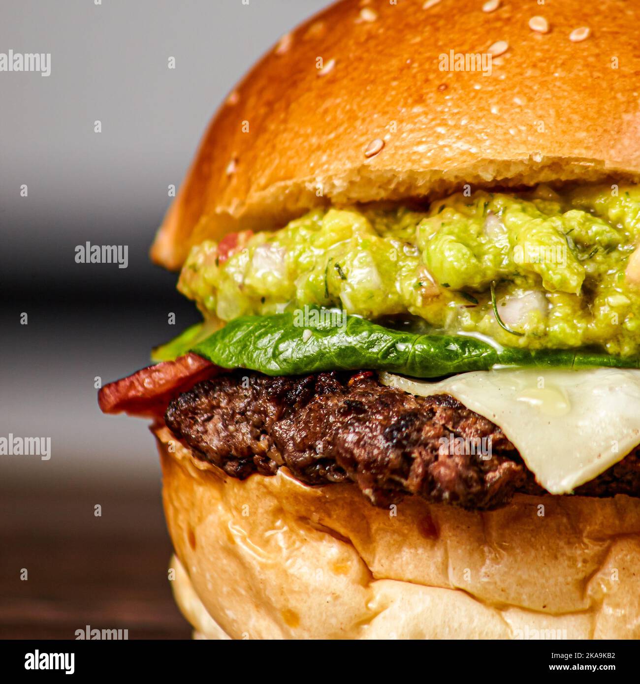 A vertical, close-up shot of a juicy hamburger isolated on a blurred ...