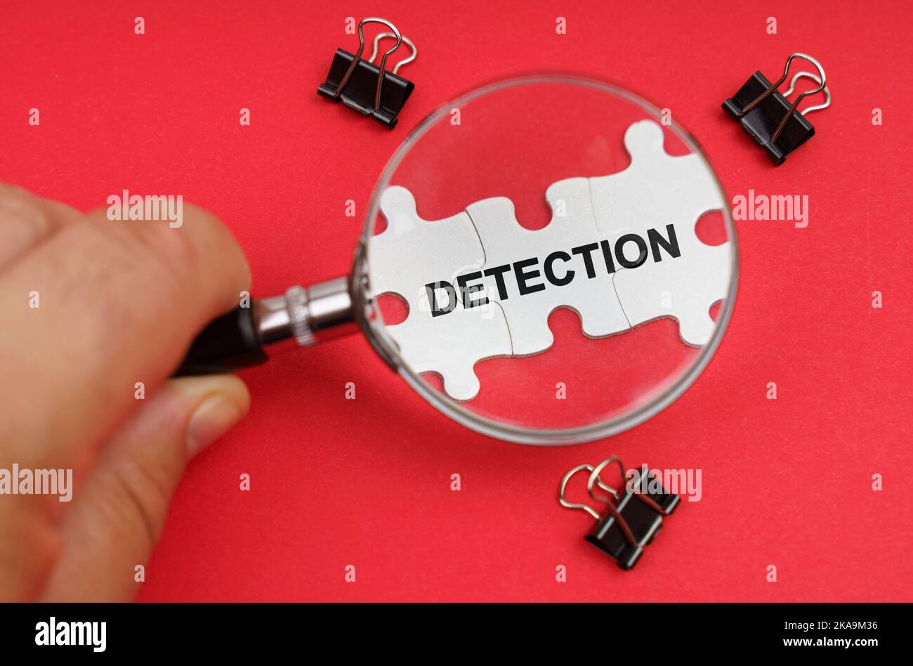 Business concept. A man looks through a magnifying glass at puzzles ...