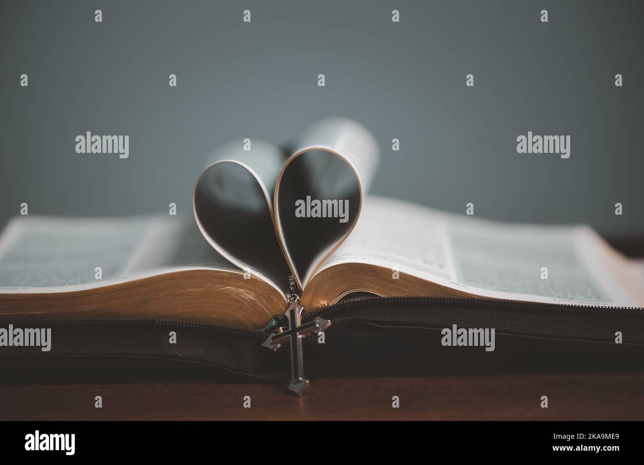 Open spiritual holy bible book with heart shape page folded in the ...