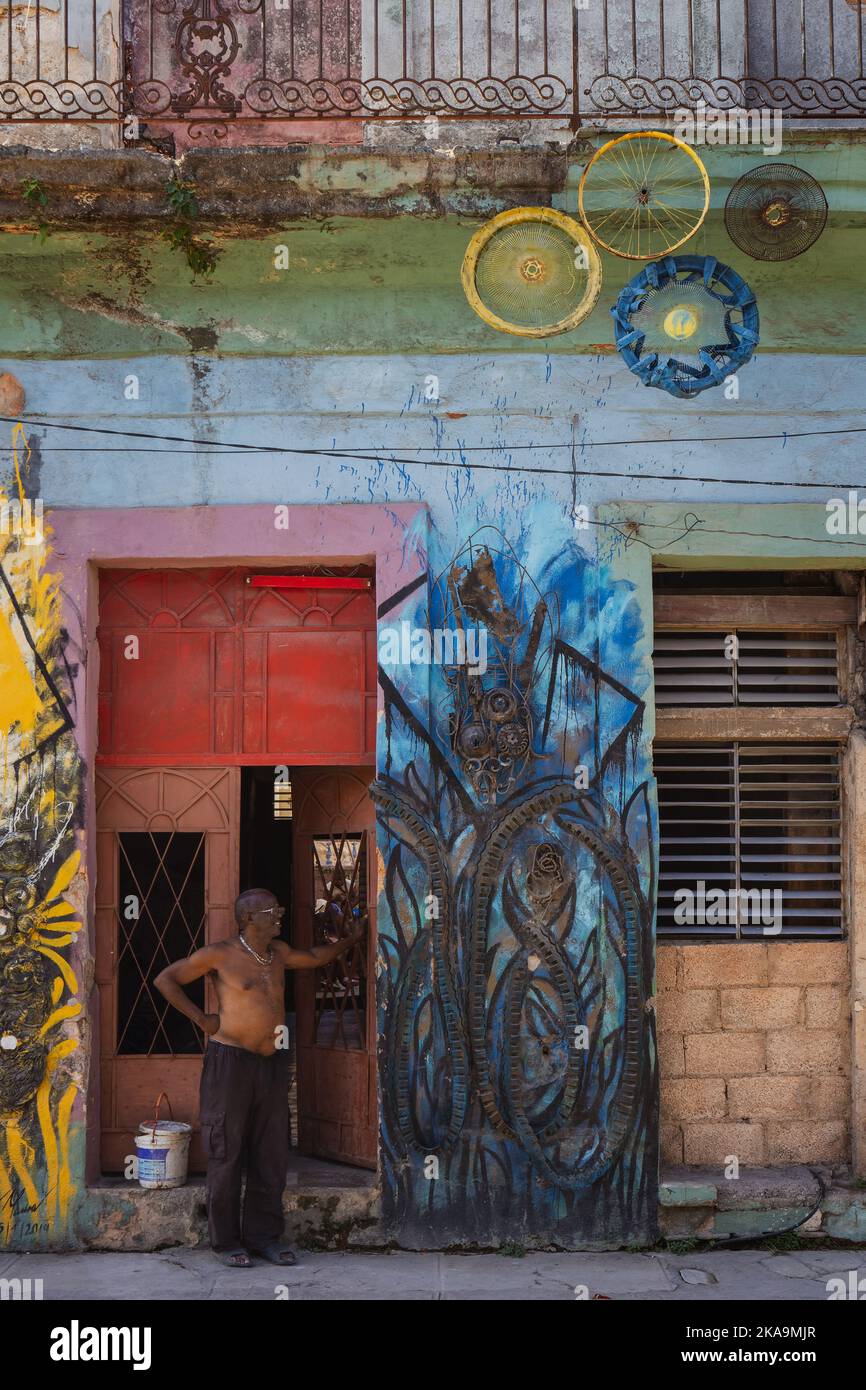 A vertical shot of a man standing near graffiti walls Stock Photo - Alamy