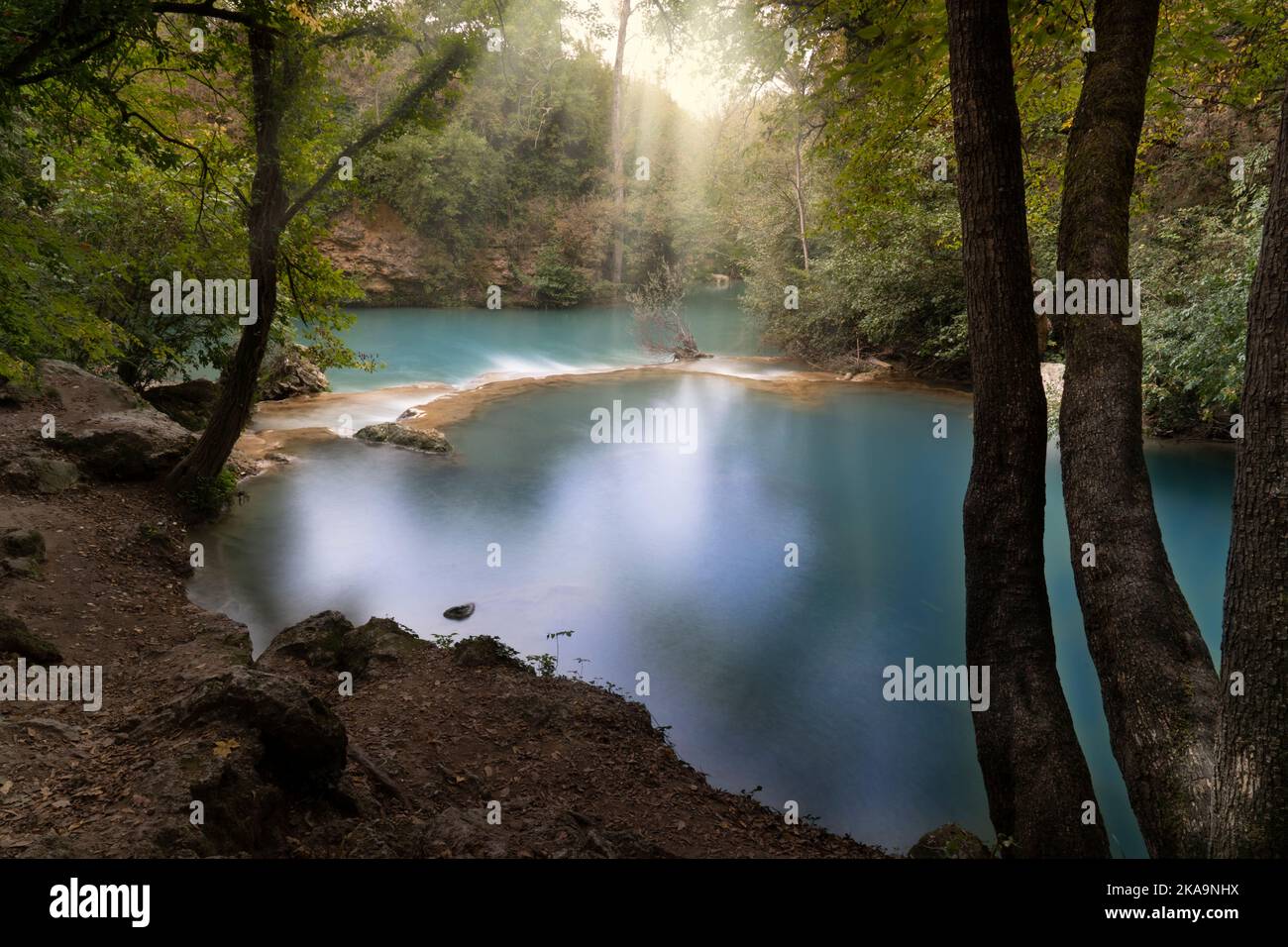 river with waterfalls inside a wood with sunbeams in tuscany Stock ...