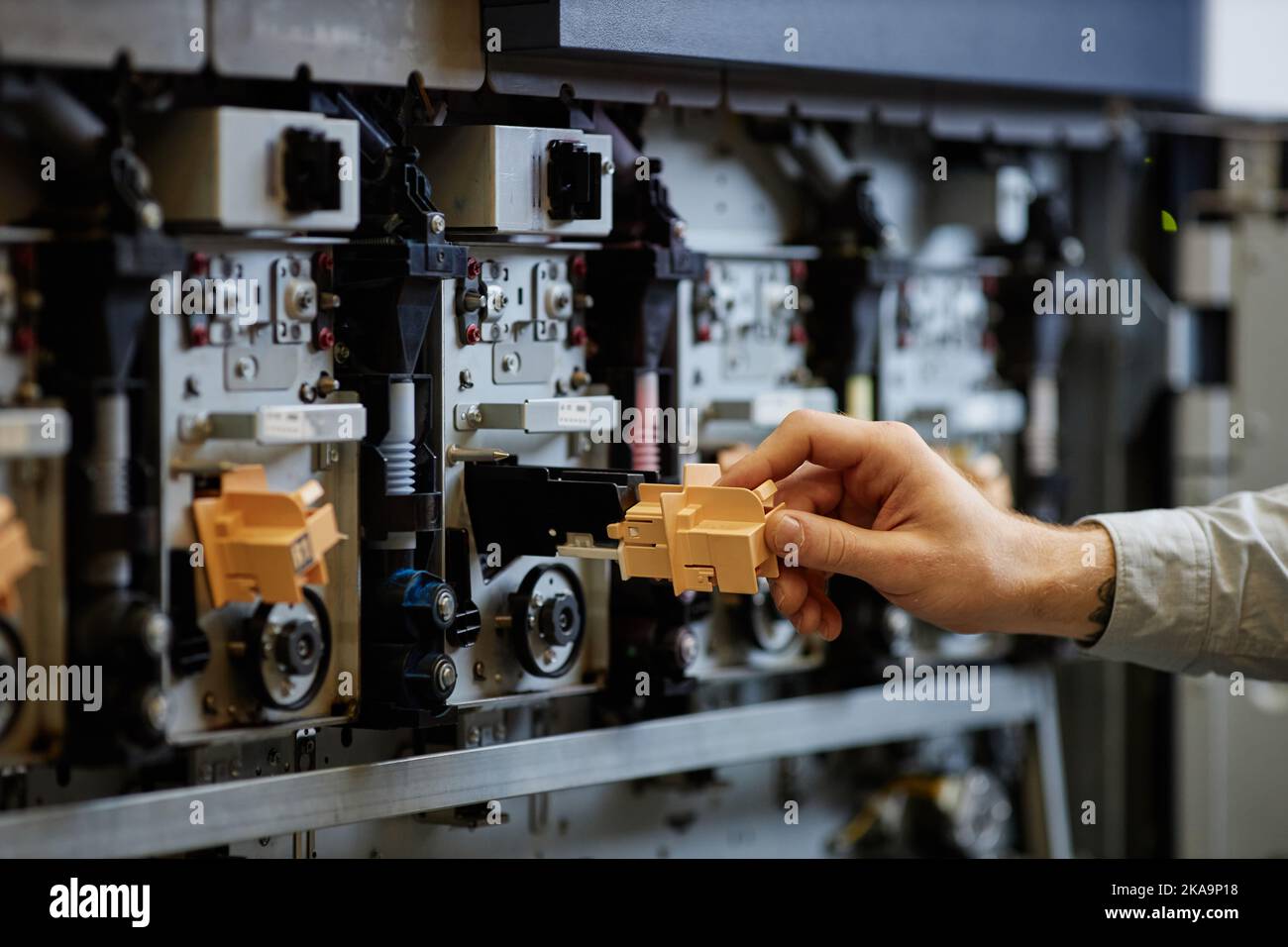 Close up of worker setting up industrial printing machines with focus ...