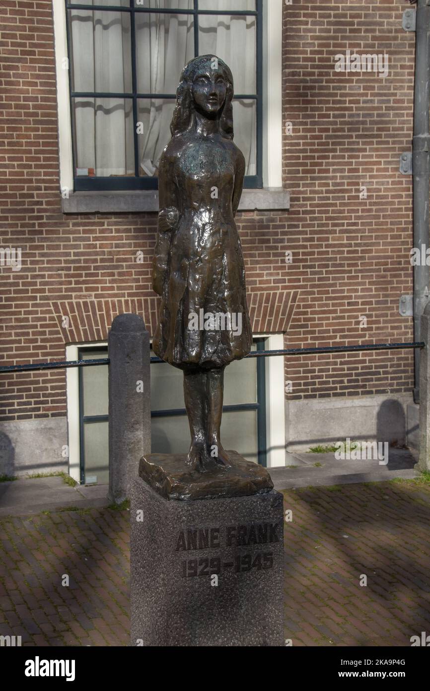 A vertical shot of the Anne Frank sculpture against a brick wall in ...