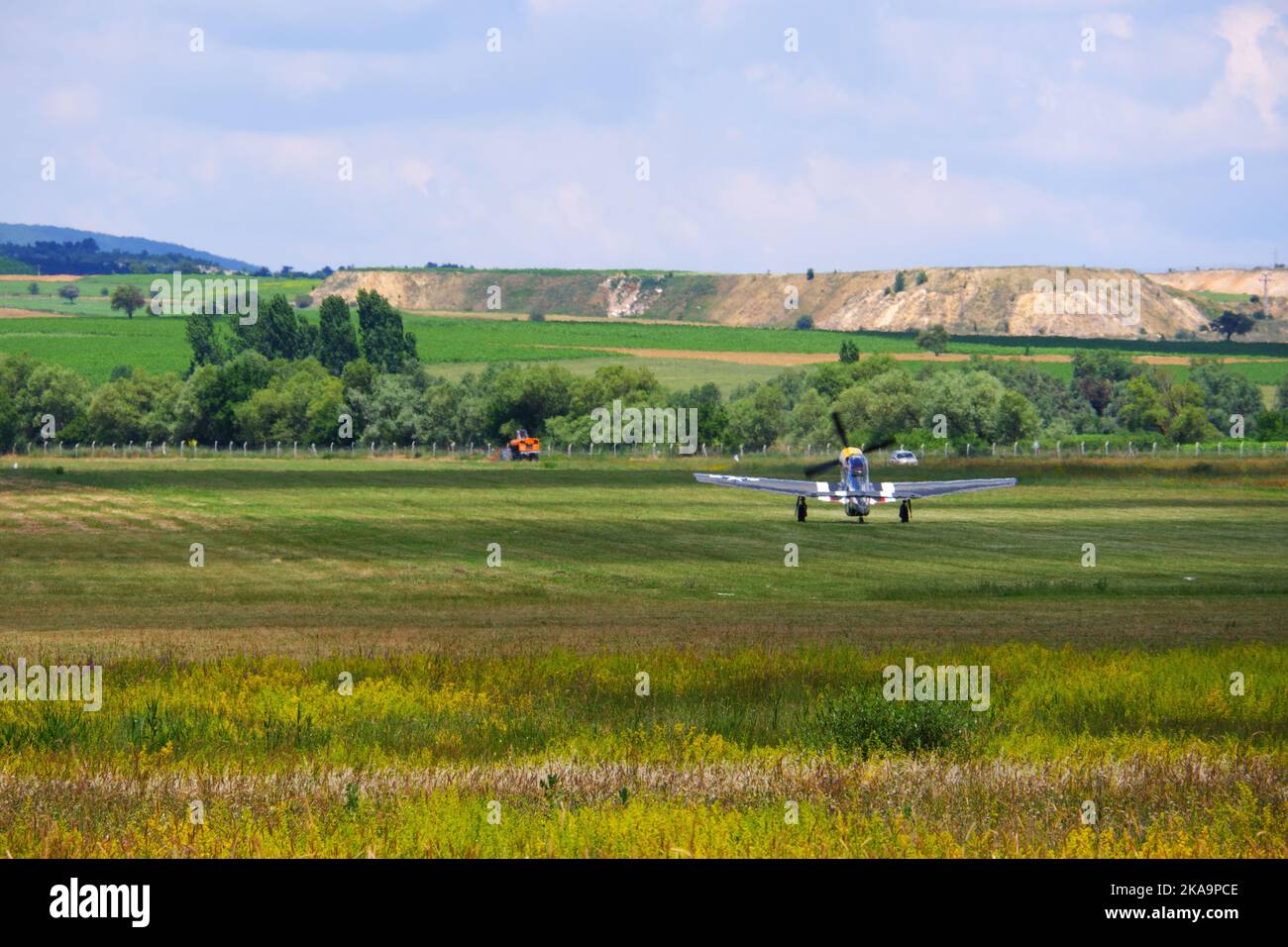 Plane ready for take off over hills. waiting on grass outdoor in nature ...