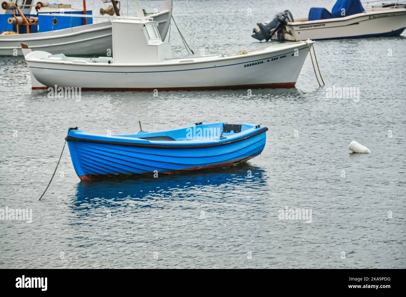 A beautiful small blue boat in the water with a white boat, village ...