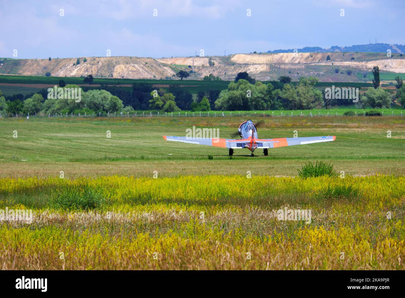 Plane ready for take off over hills. waiting on grass outdoor in nature ...