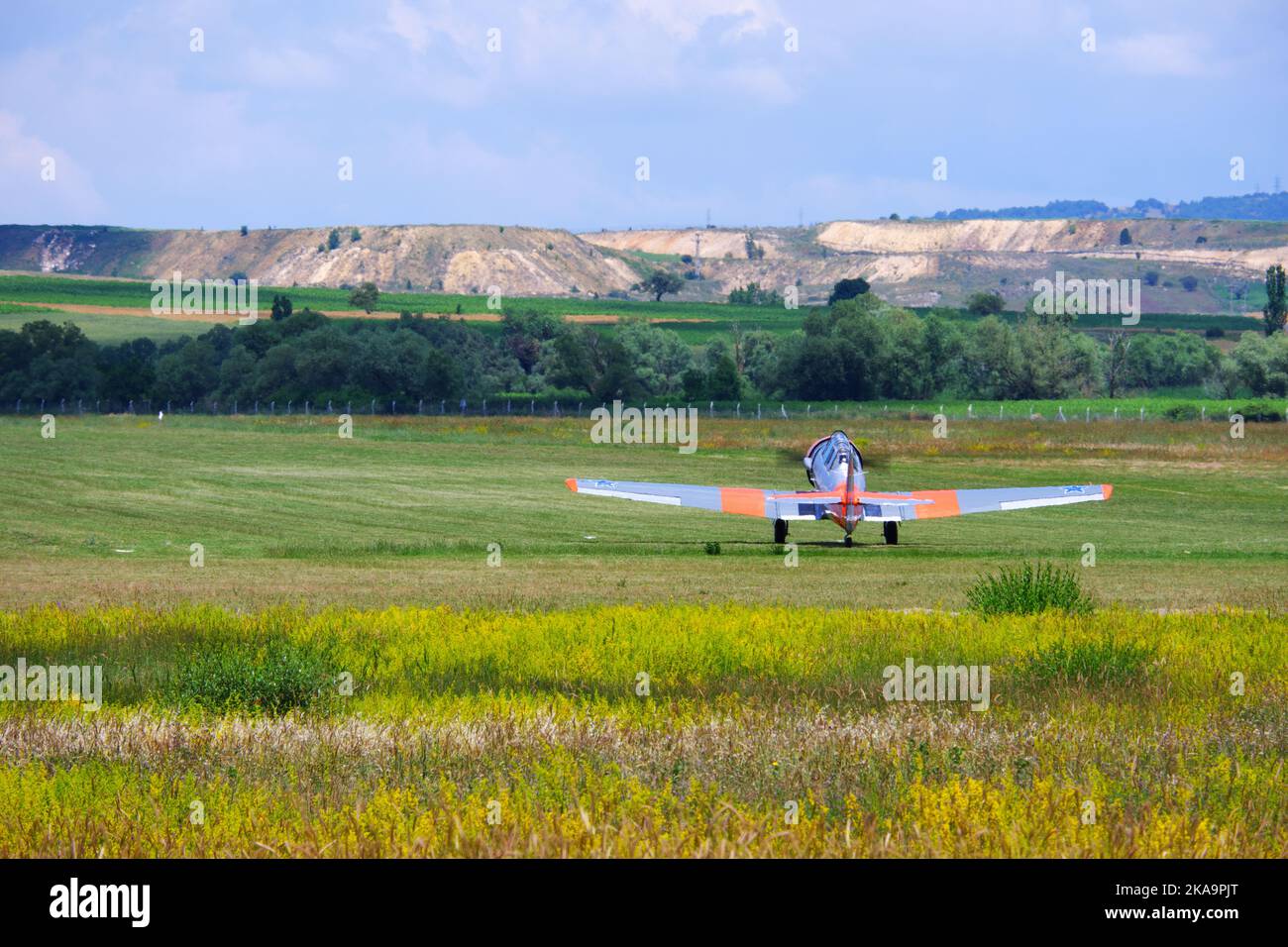 Plane ready for take off over hills. waiting on grass outdoor in nature ...