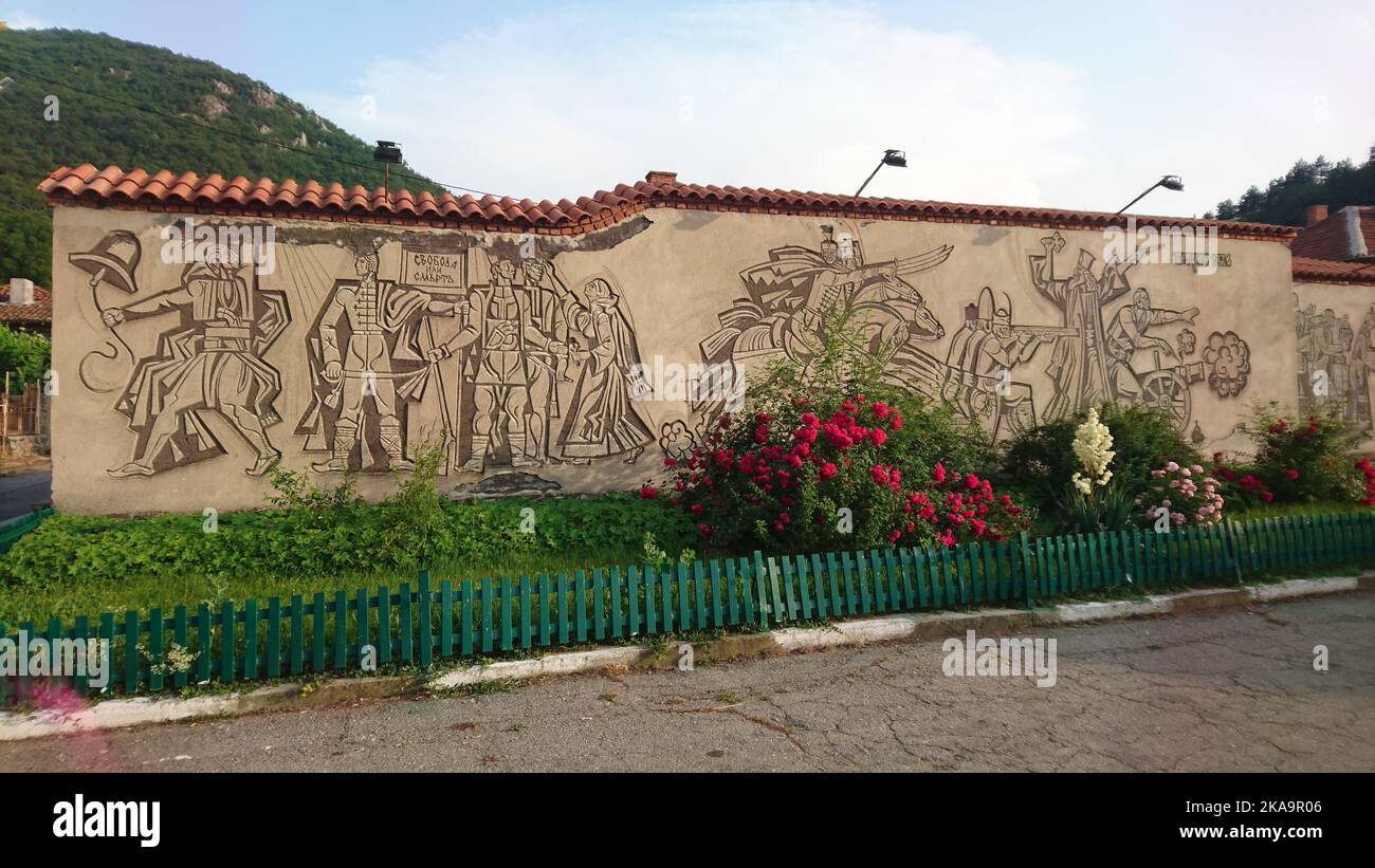 A beautiful shot of a wall covered with Soviet Murals against flowers ...