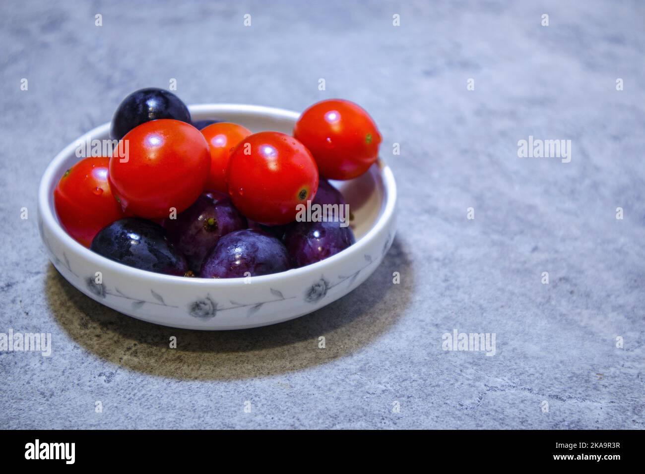 A close-up of grapes and cherry tomatoes on a plate Stock Photo - Alamy