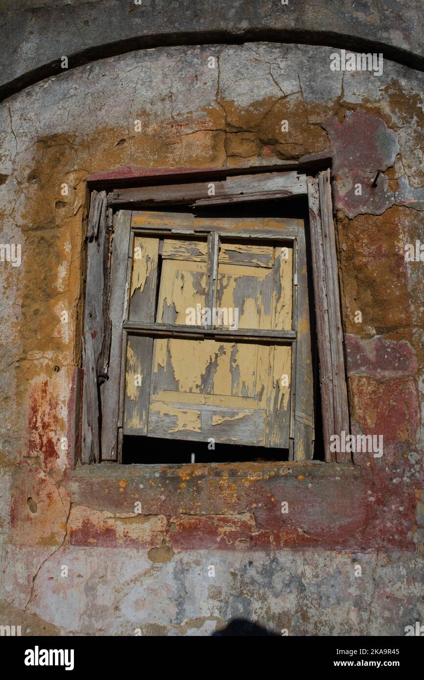A vertical closeup of the grungy, weathered house wall with a broken ...