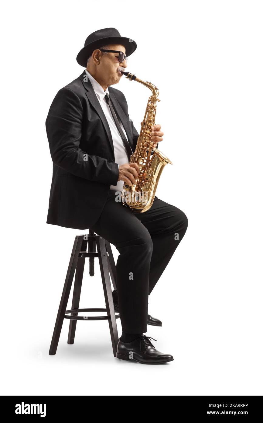 Mature man playing a sax and sitting on a chair isolated on white ...