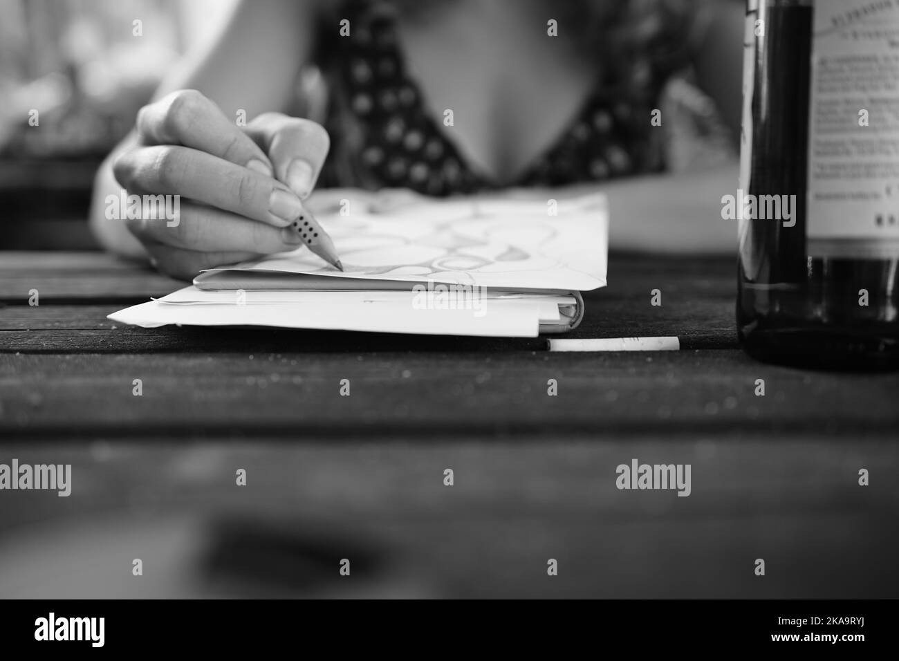 A grayscale of a beautiful woman drawing on a paper Stock Photo - Alamy