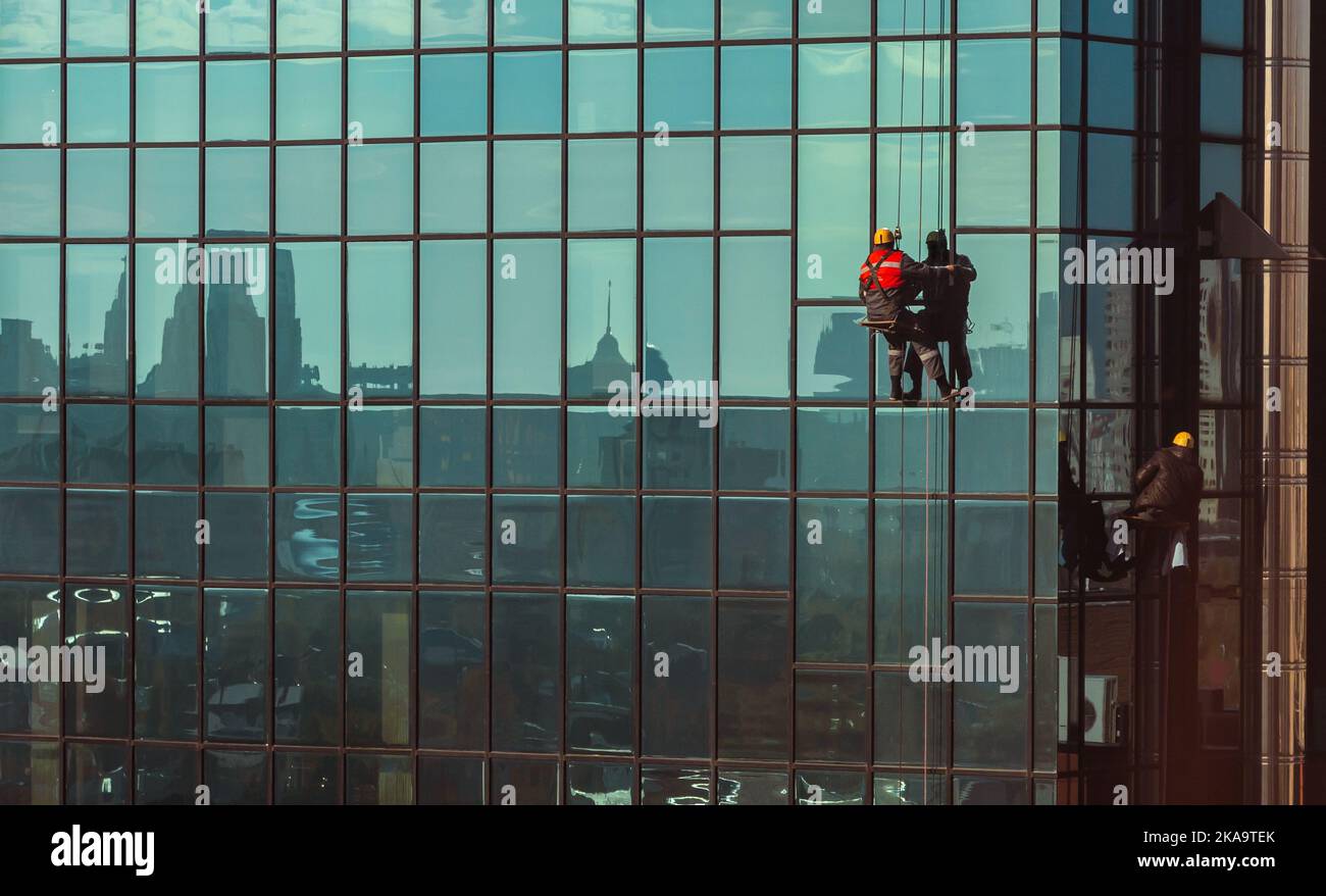 High-rise workers wash the facade and glass of a skyscraper Stock Photo ...