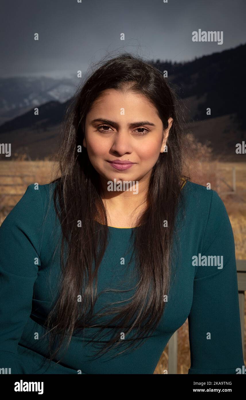 Beautiful young woman with long black hair, looking towards the camera ...