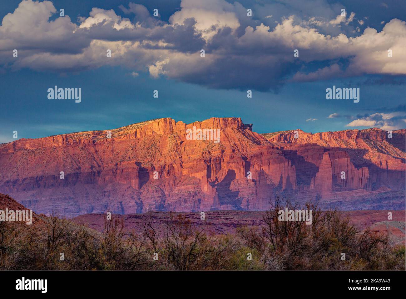 WIngate sandstone cliffs of Waring Mesa with the Fisher Towers in front ...