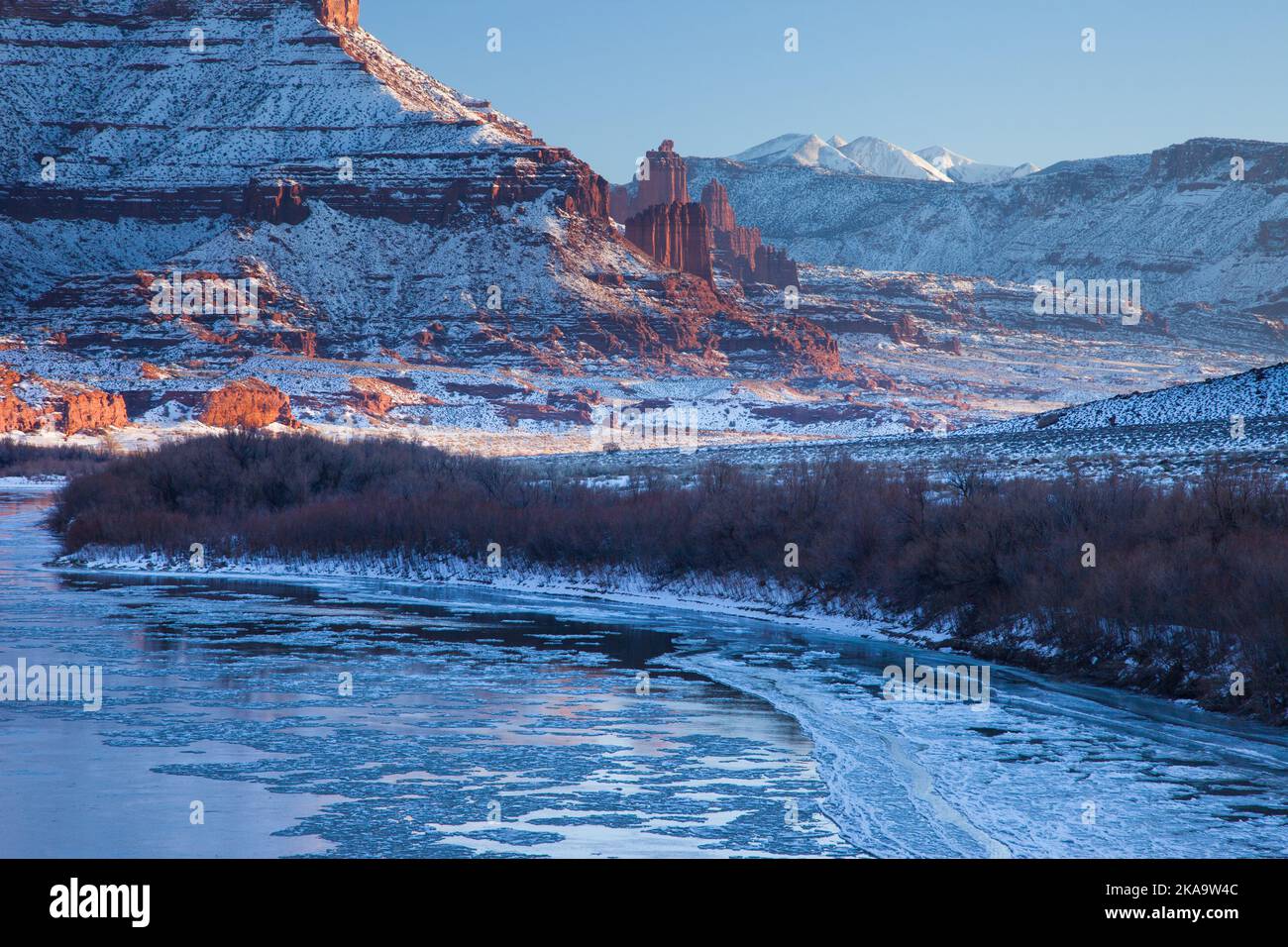 Fisher Towers over the icy Colorado River at sunset in winter with the ...