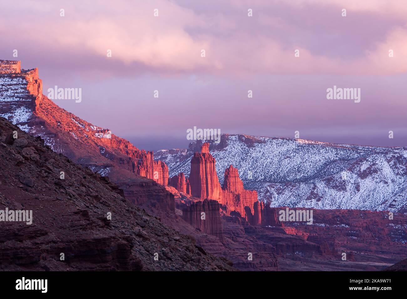 Fisher Towers over the frozen Colorado River at sunset in winter with ...