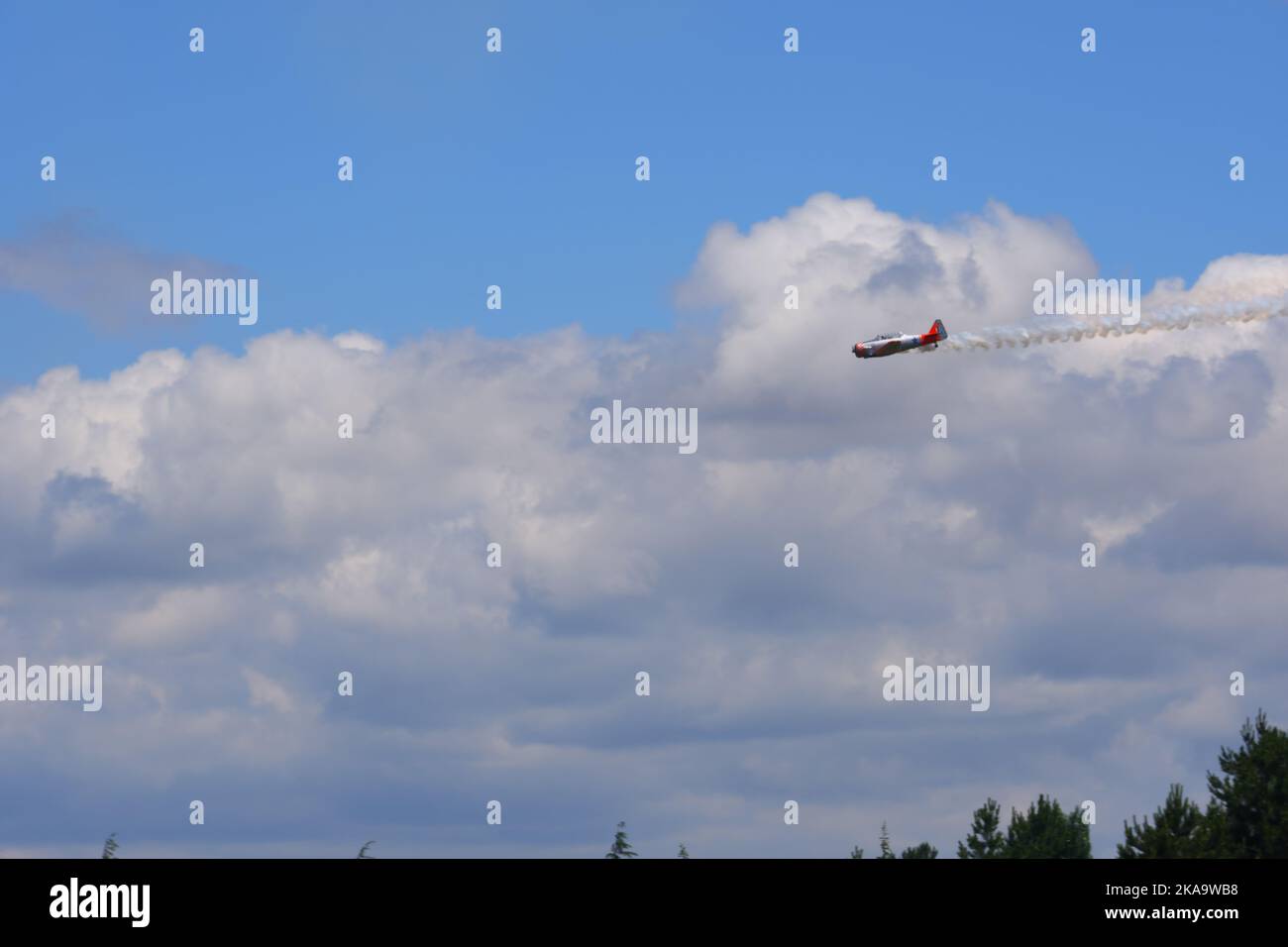 Plane flying within dark clouds with smoke on tail Stock Photo - Alamy