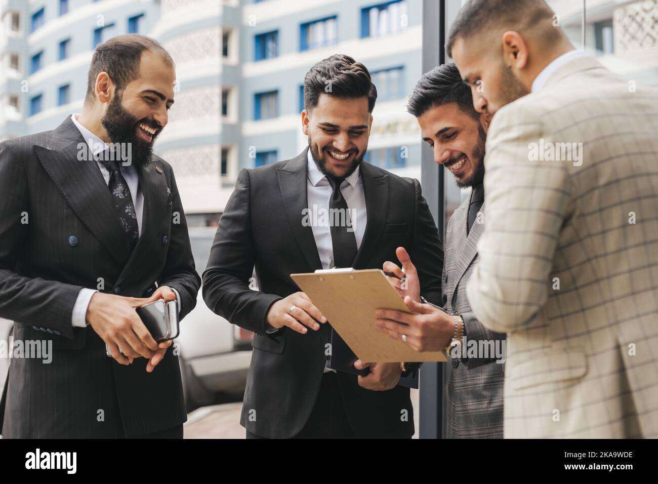 Business people outdoor meeting. Men in jackets discuss working moments ...