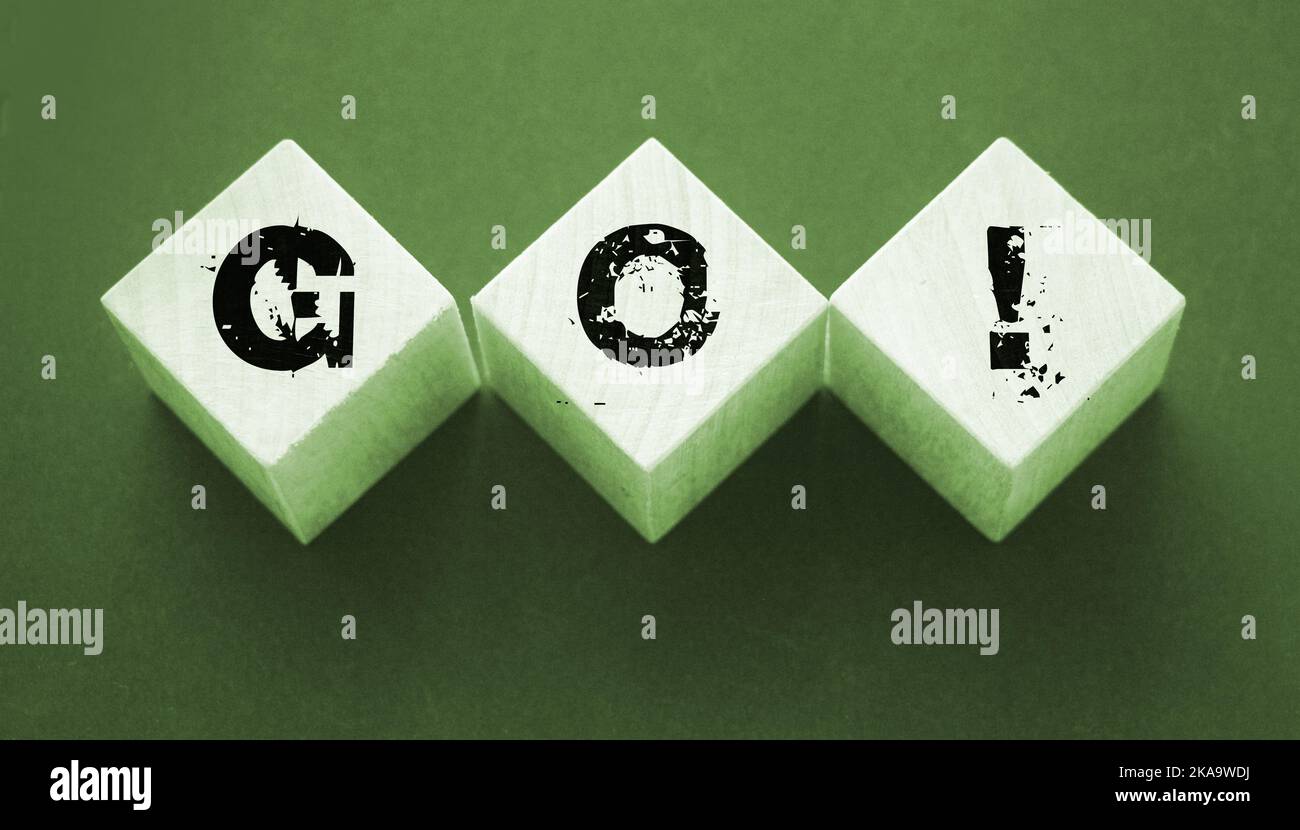 Go word on wooden cubes on black background. New begining concept ...