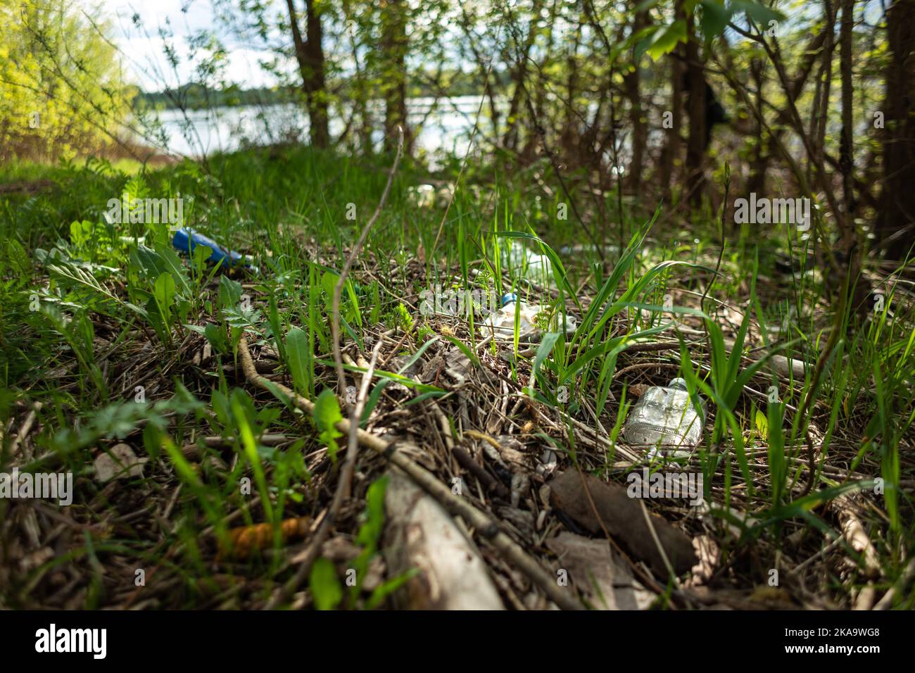 Abandoned garbage plastic and glass waste in nature among the grass ...