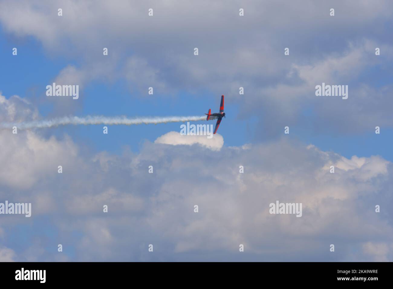 Plane flying within dark clouds with smoke on tail Stock Photo - Alamy