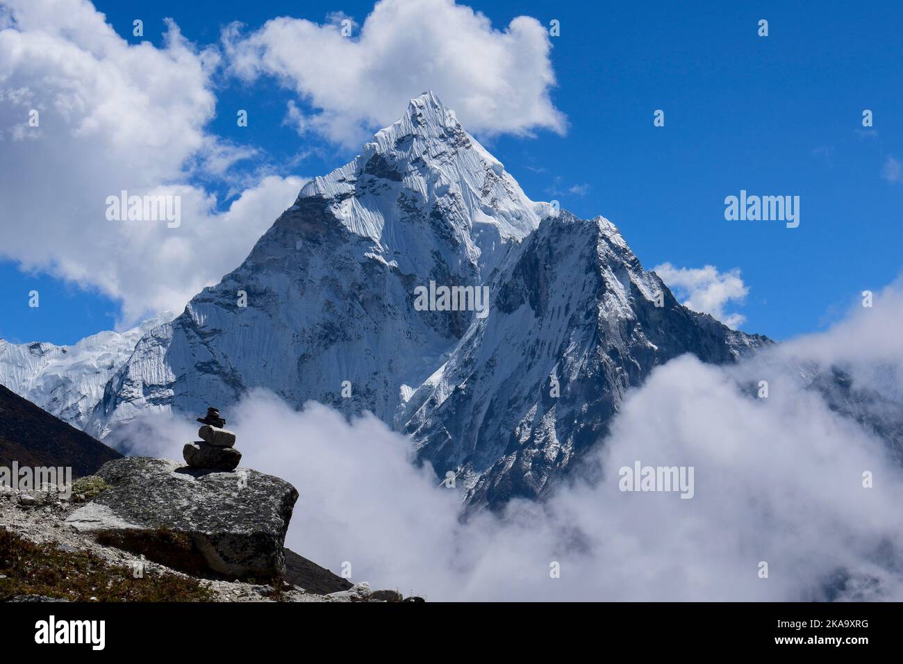 A beautiful shot of mount Everest surrounded by clouds and a stack of ...