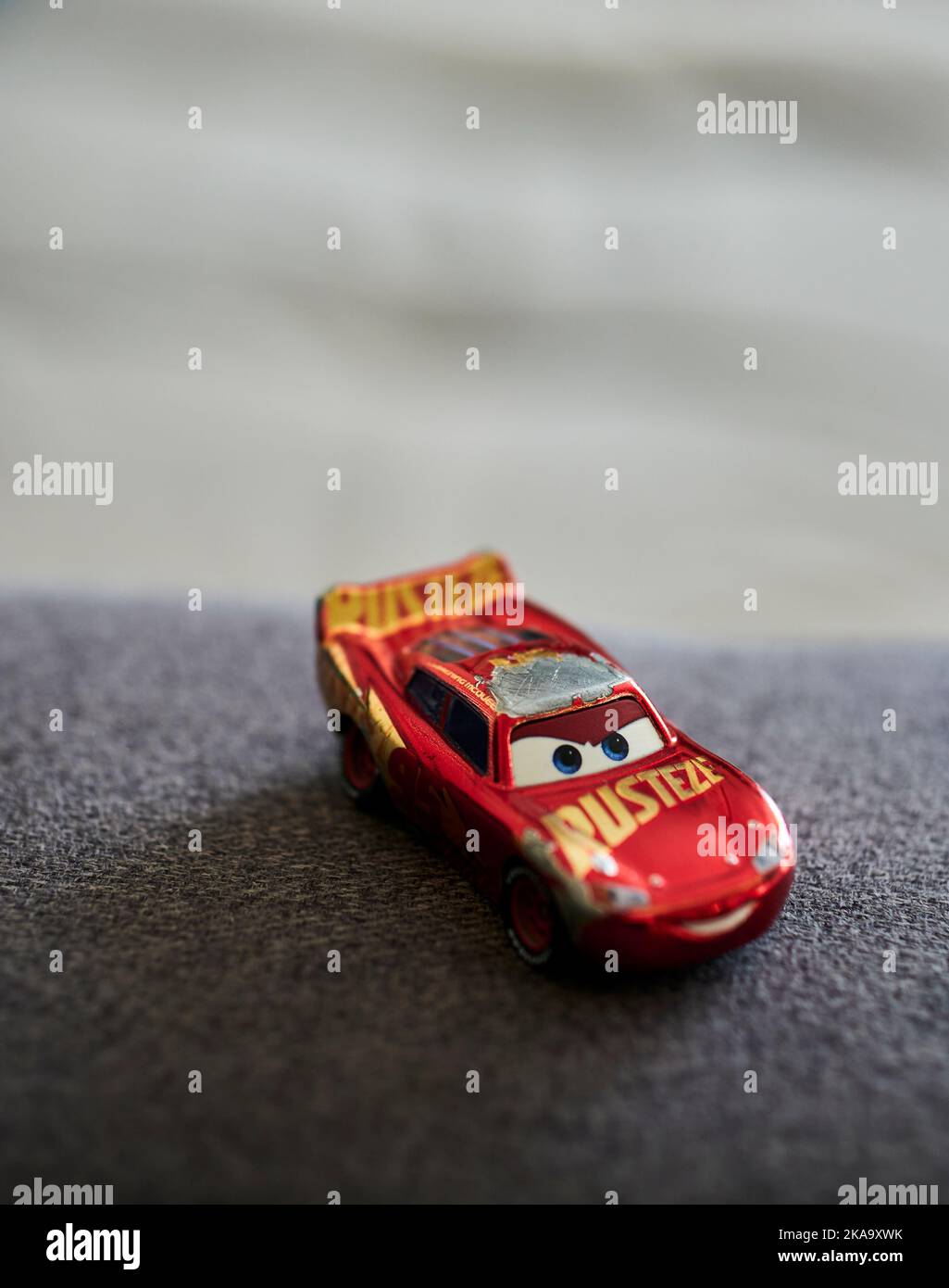 A closeup shot of a red Mattel Lightning McQueen toy model sport car ...